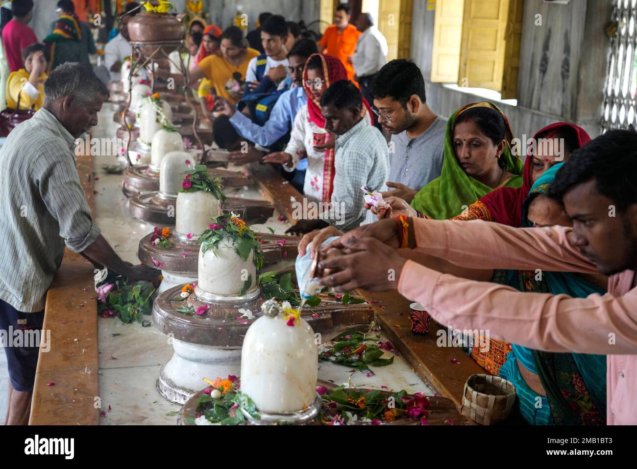 Hindu devotees offer prayers to a row of Shivlings, idols symbolic of ...