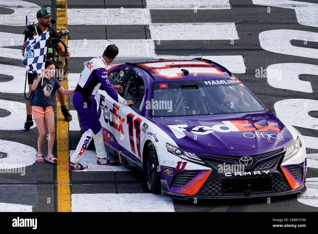 Taylor James Hamlin, left, brings the checkered flag to her dad, Denny ...