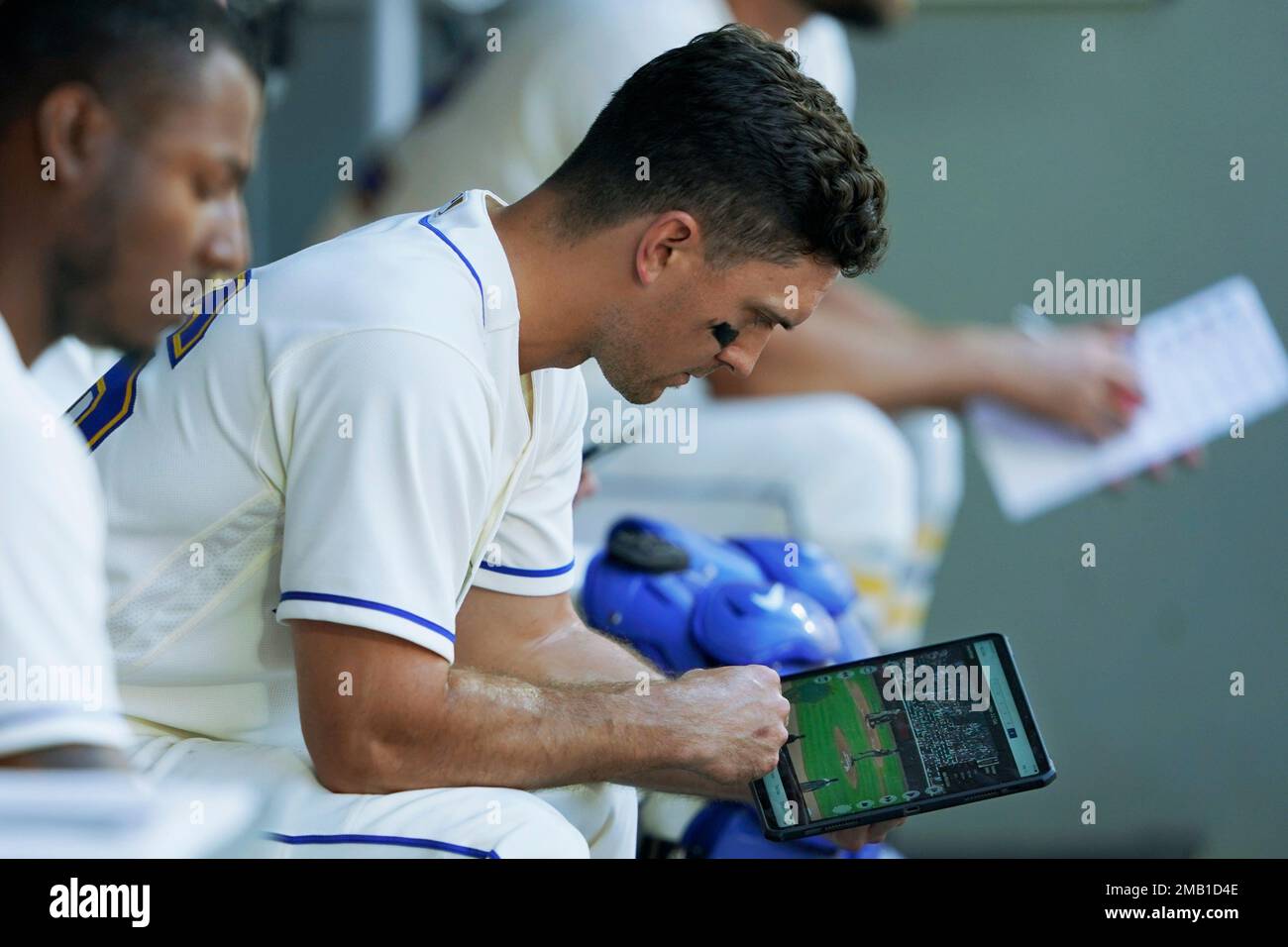Seattle Mariners' Adam Frazier, center, studies video on a tablet as he ...
