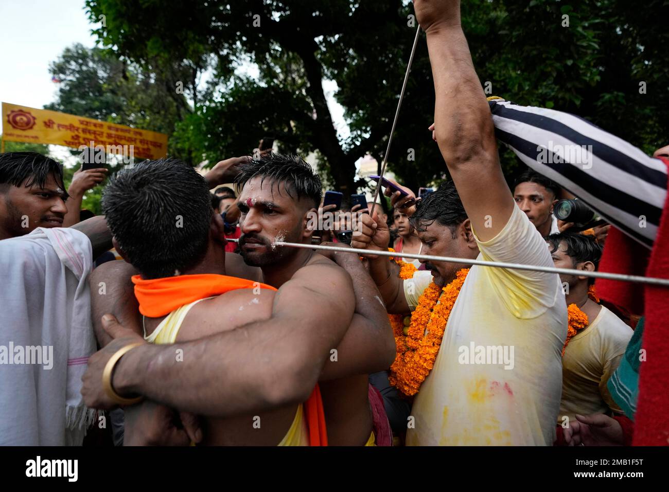 An Indian Hindu devotee gets hooks pierced on his back after piercing a ...