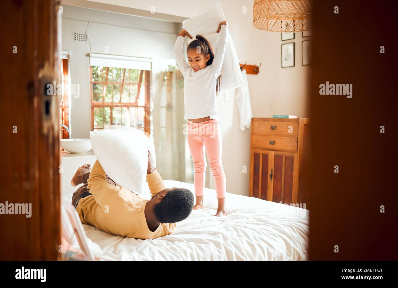 Pillow fight, home and family bonding with a father and child having ...