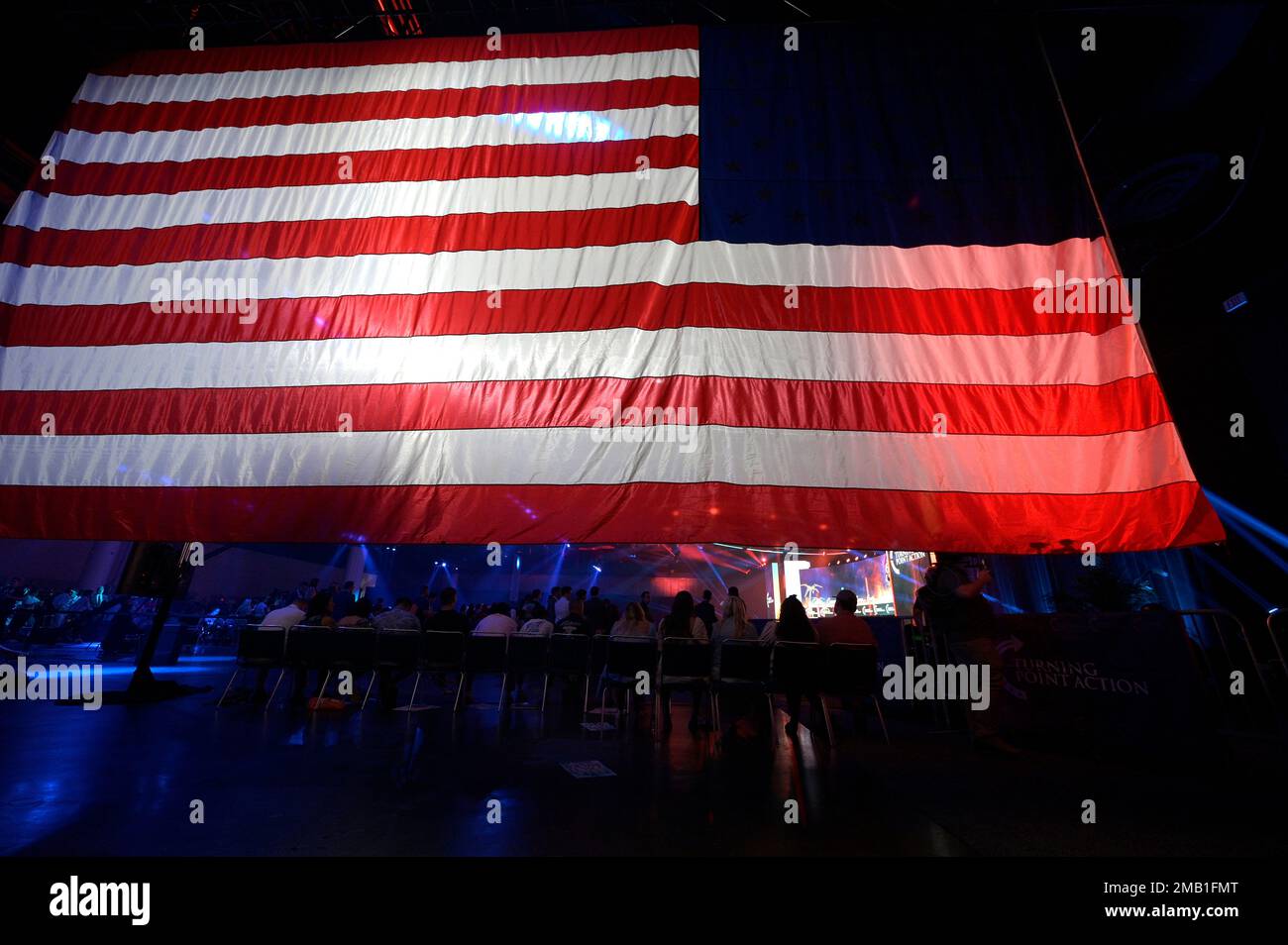 A United States flag hangs behind attendees during the Turning Point ...
