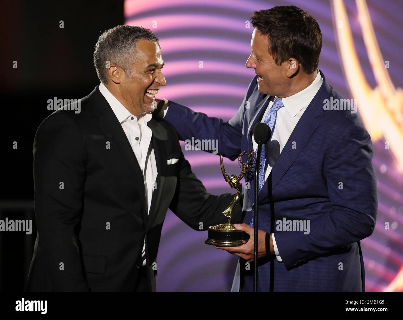 John Hartung of Spectrum SportsNet LA, right, presents the Emmy to ...