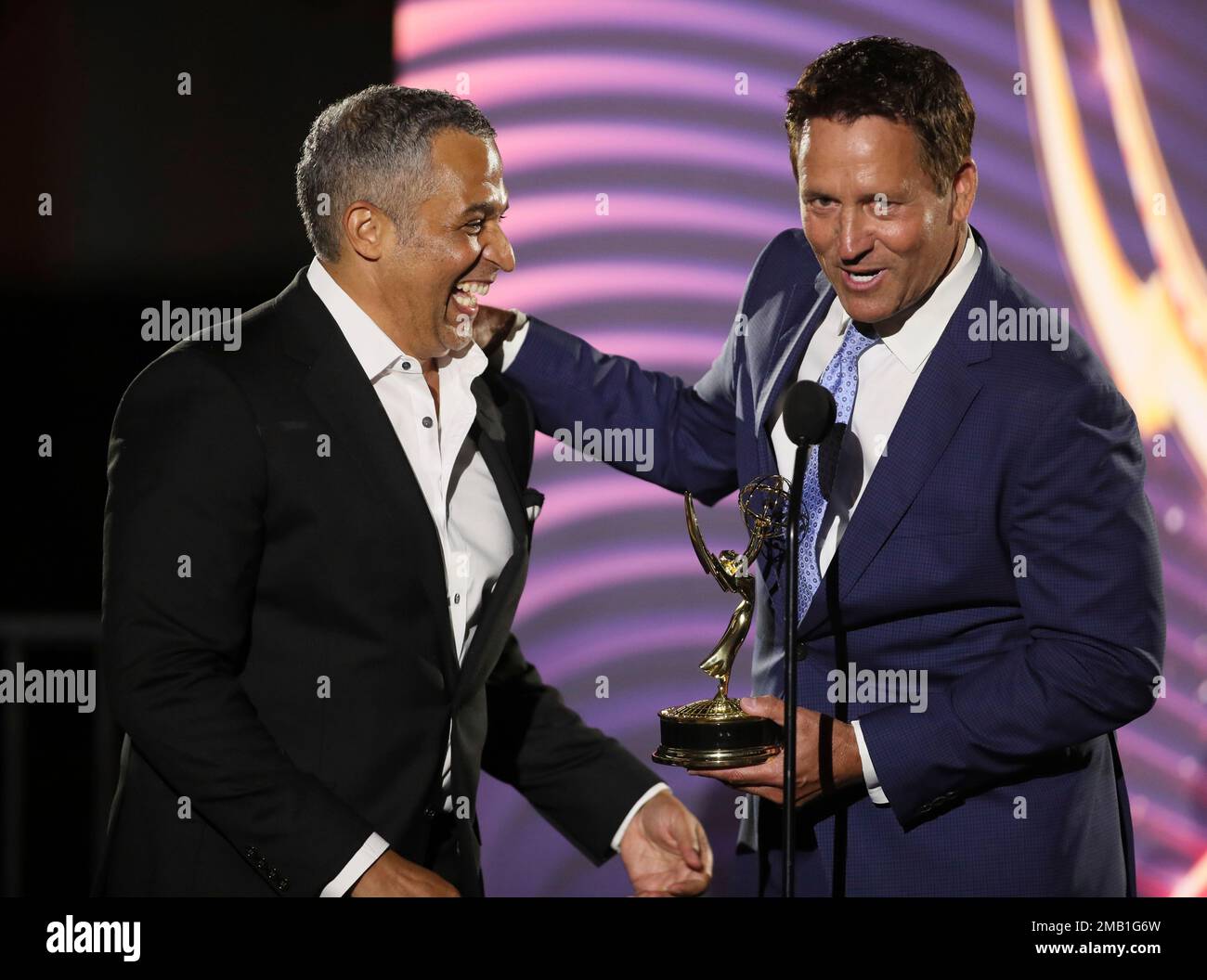 John Hartung of Spectrum SportsNet LA, right, presents the Emmy to ...