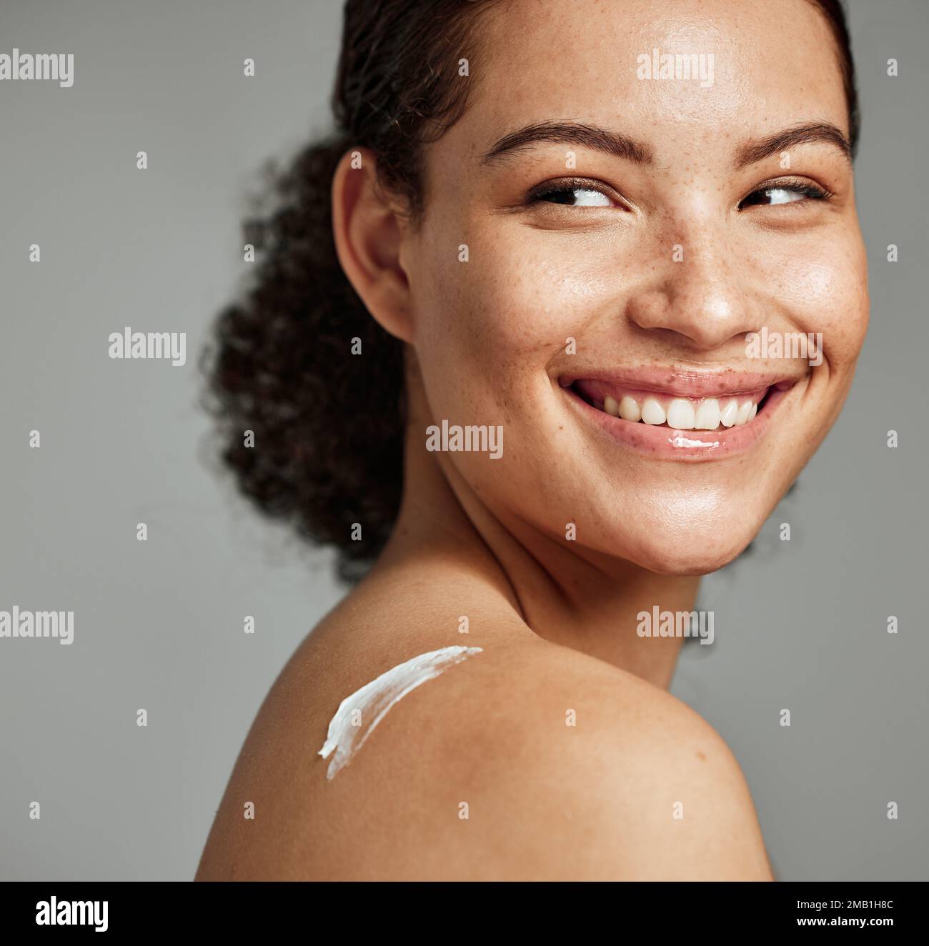 Face, skincare and woman with back cream in studio isolated on gray ...