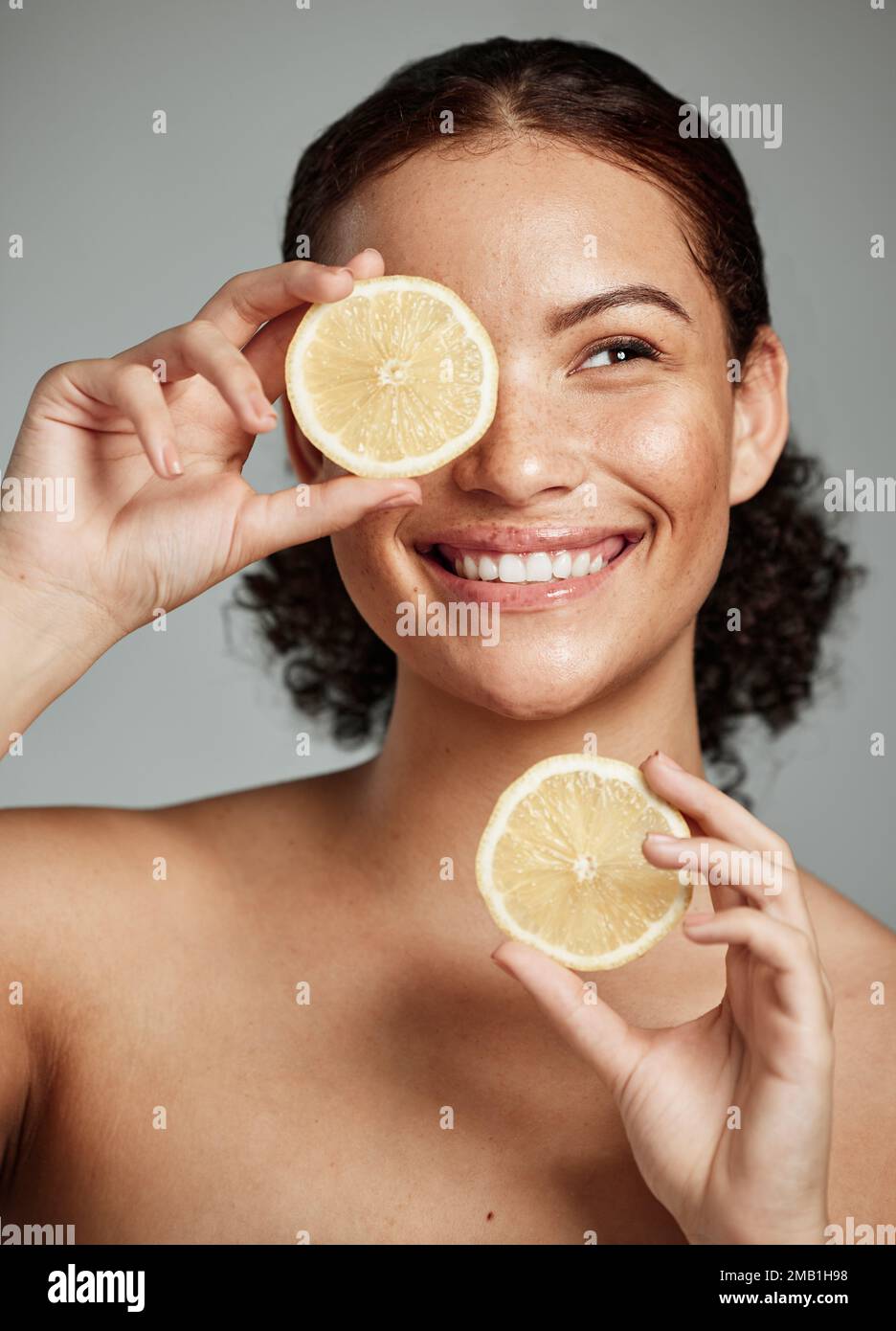 Face, skincare and woman with lemon in studio isolated on a gray ...