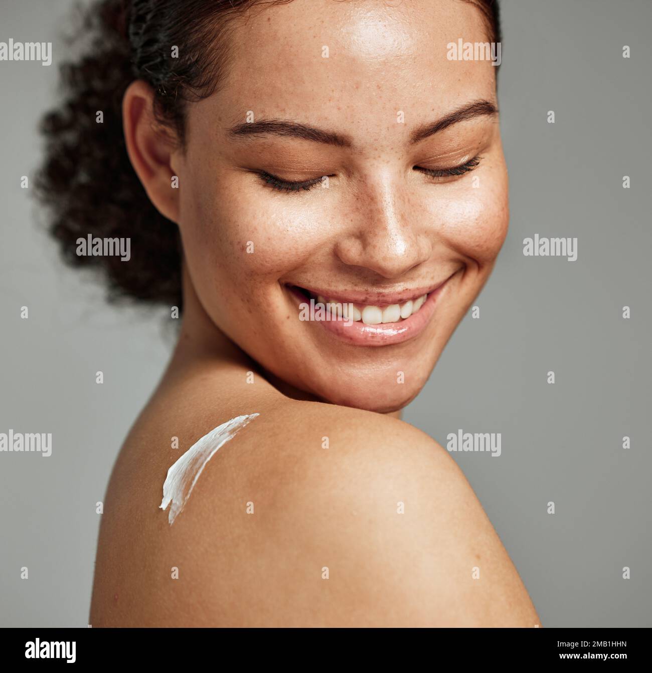 Face, skincare and back of woman with cream in studio isolated on gray ...