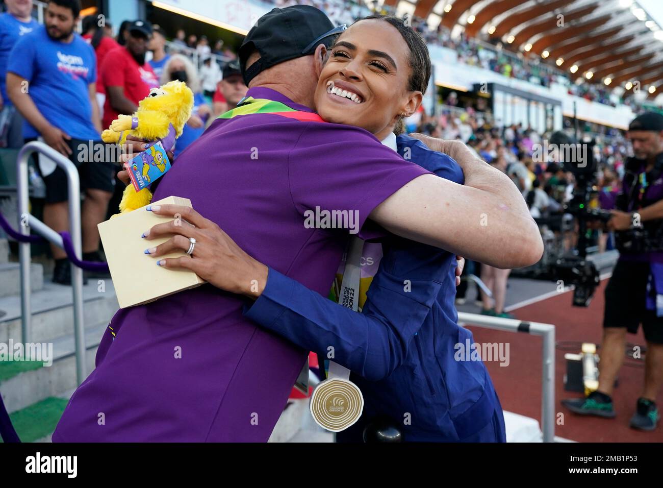 Larry Calloway, left, embraces Gold medalist Sydney Mclaughlin, of the ...