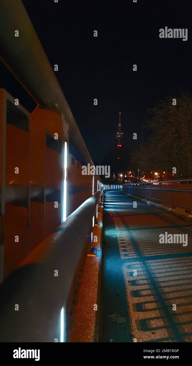 A vertical shot of neon lights on handrails of a bridge at night Stock ...