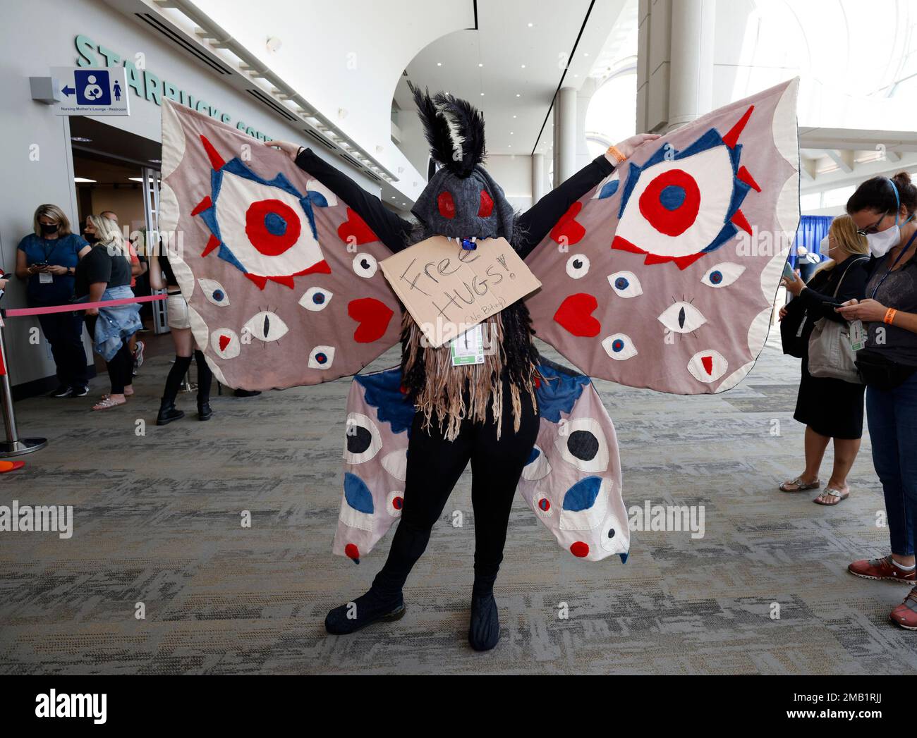 Bert Rotzler, of San Diego, dressed as Mothman, wears a sign offering ...