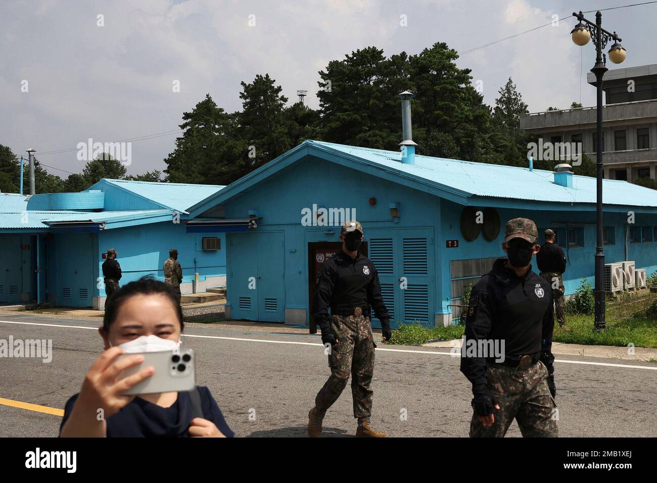 A journalist takes a selfie as South Korean soldiers stand guard in the ...