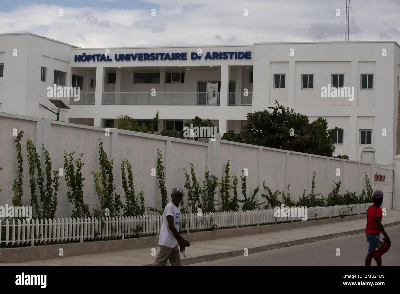 People walk past the new Dr Aristide University Hospital, in Tabarre, Haiti, Friday, July 15 ...