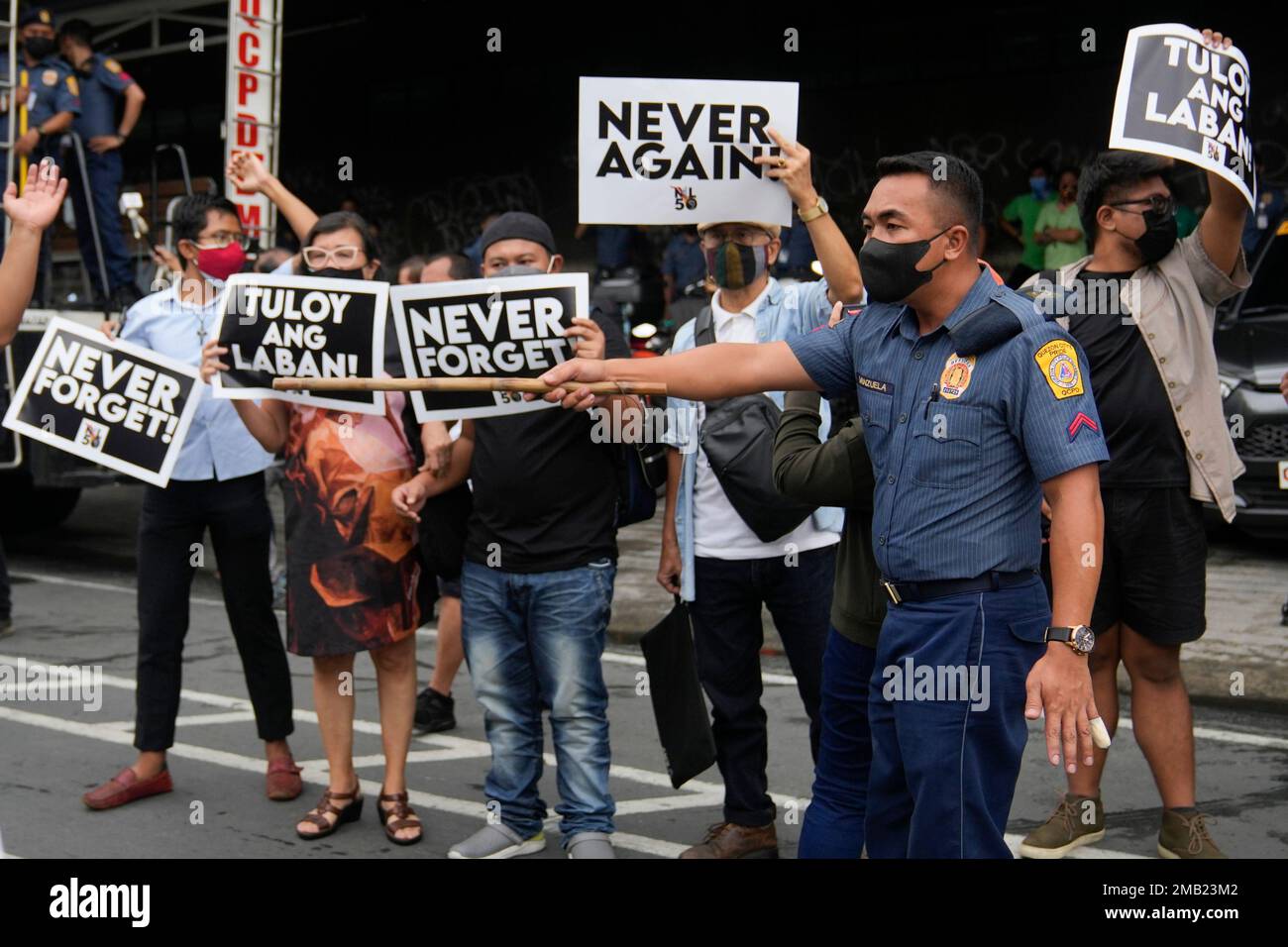 A policeman stands beside activists holding slogans during a short ...
