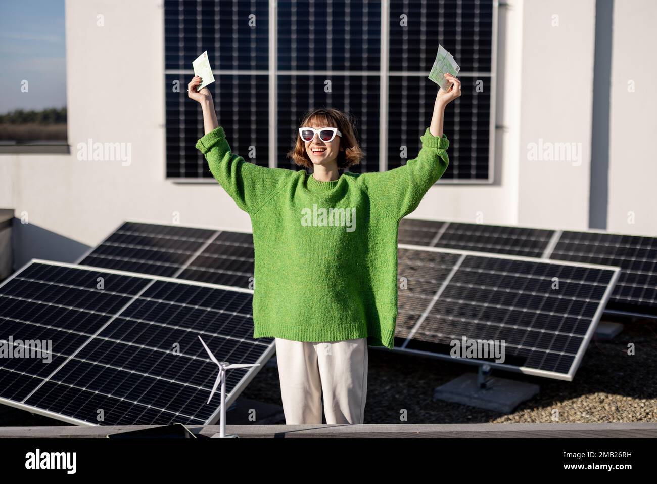 Happy household owner with money near solar power plant Stock Photo - Alamy