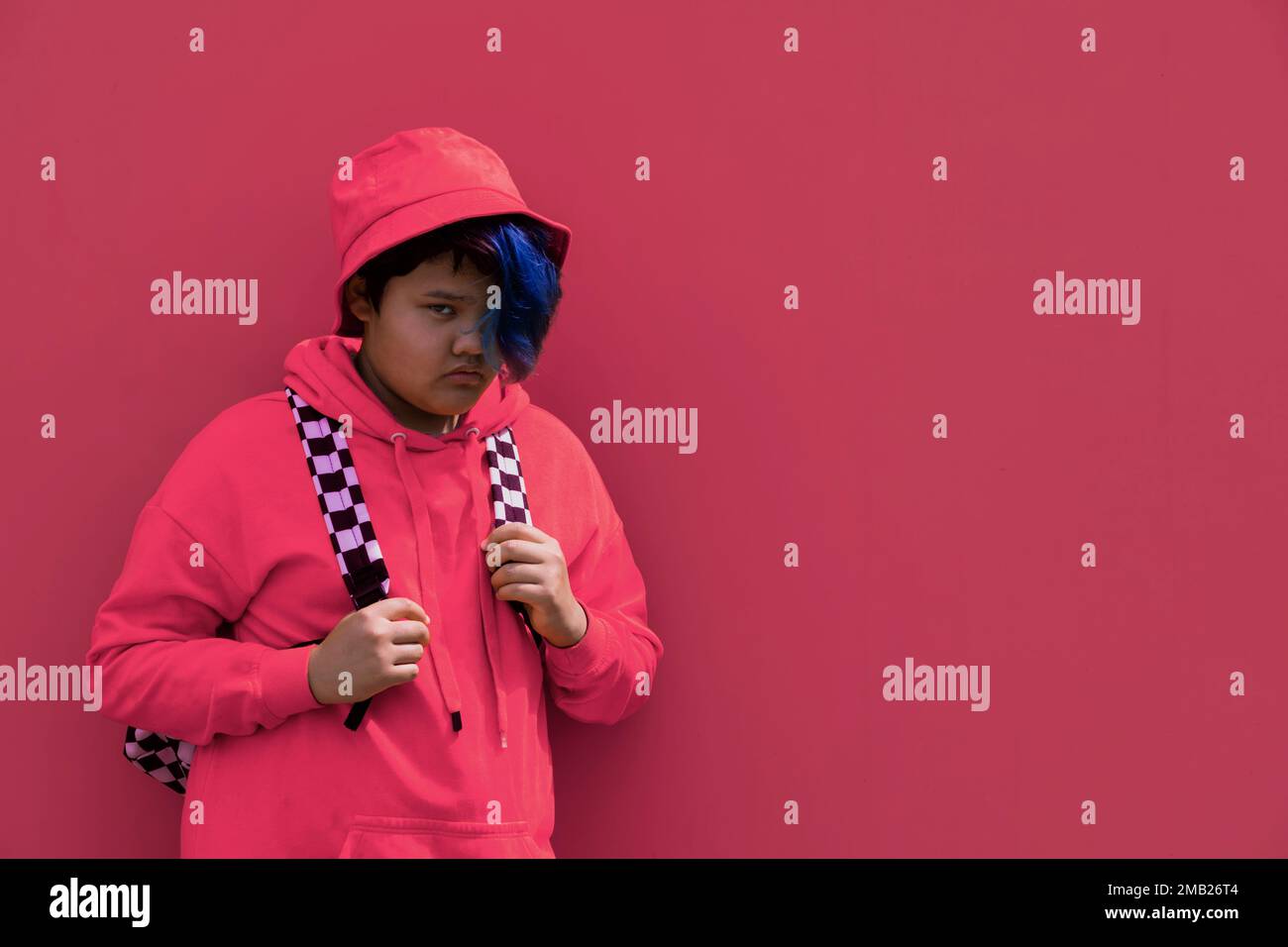 Back to school. A teenage girl with blue hair in pink hoodie, a Panama ...