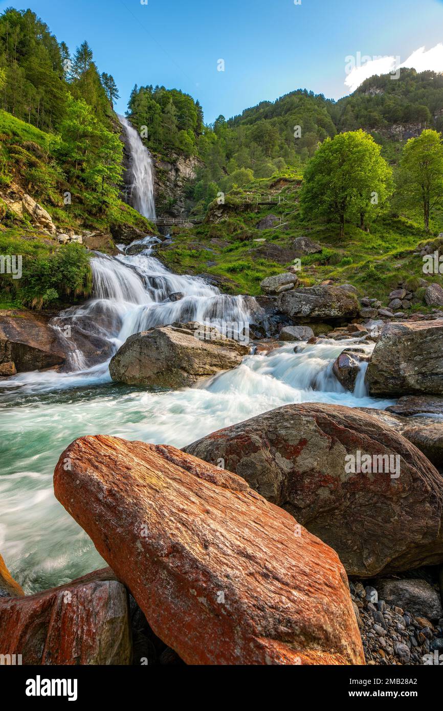 Large waterfall flowing into a stream, in a green landscape Stock Photo ...