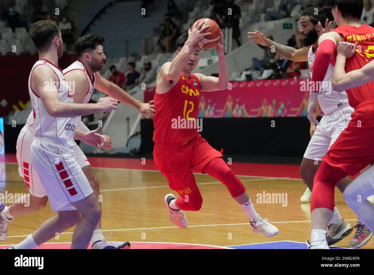 China's Gu Quan, center, drives past Lebanon's Hayk Gyokchyan, rear ...