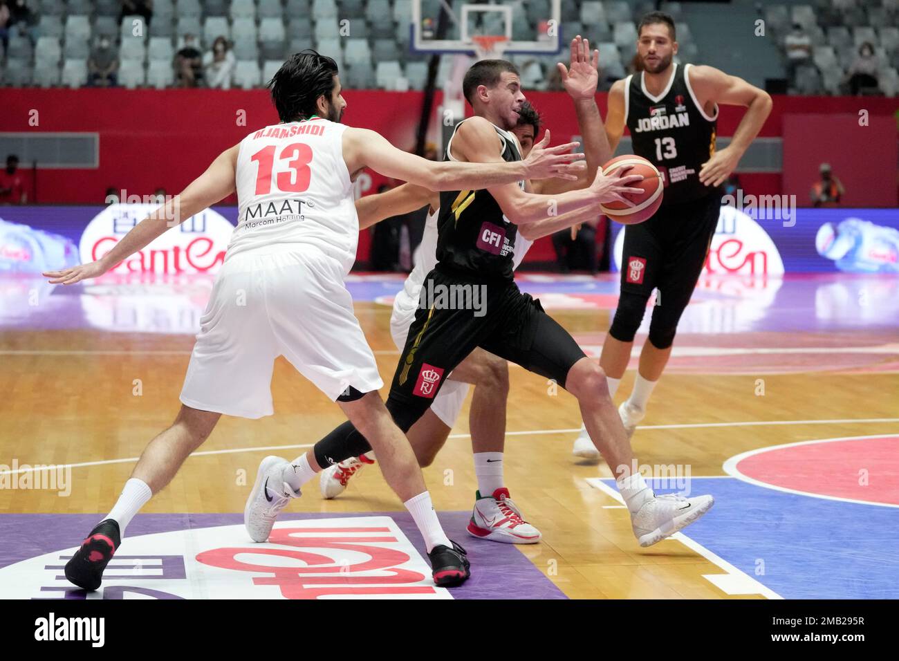 Jordan's Freddy Ibrahim, center, drives past Iran's Mohammad Jamshidi ...