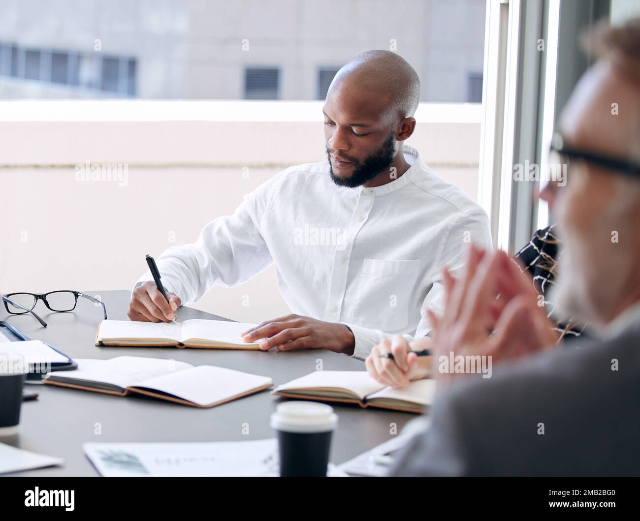 Boldness, be my friend. a young businessman taking notes in a modern ...
