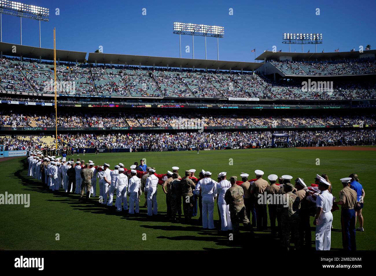 Military personnel hold a U.S. flag before the MLB All-Star baseball ...