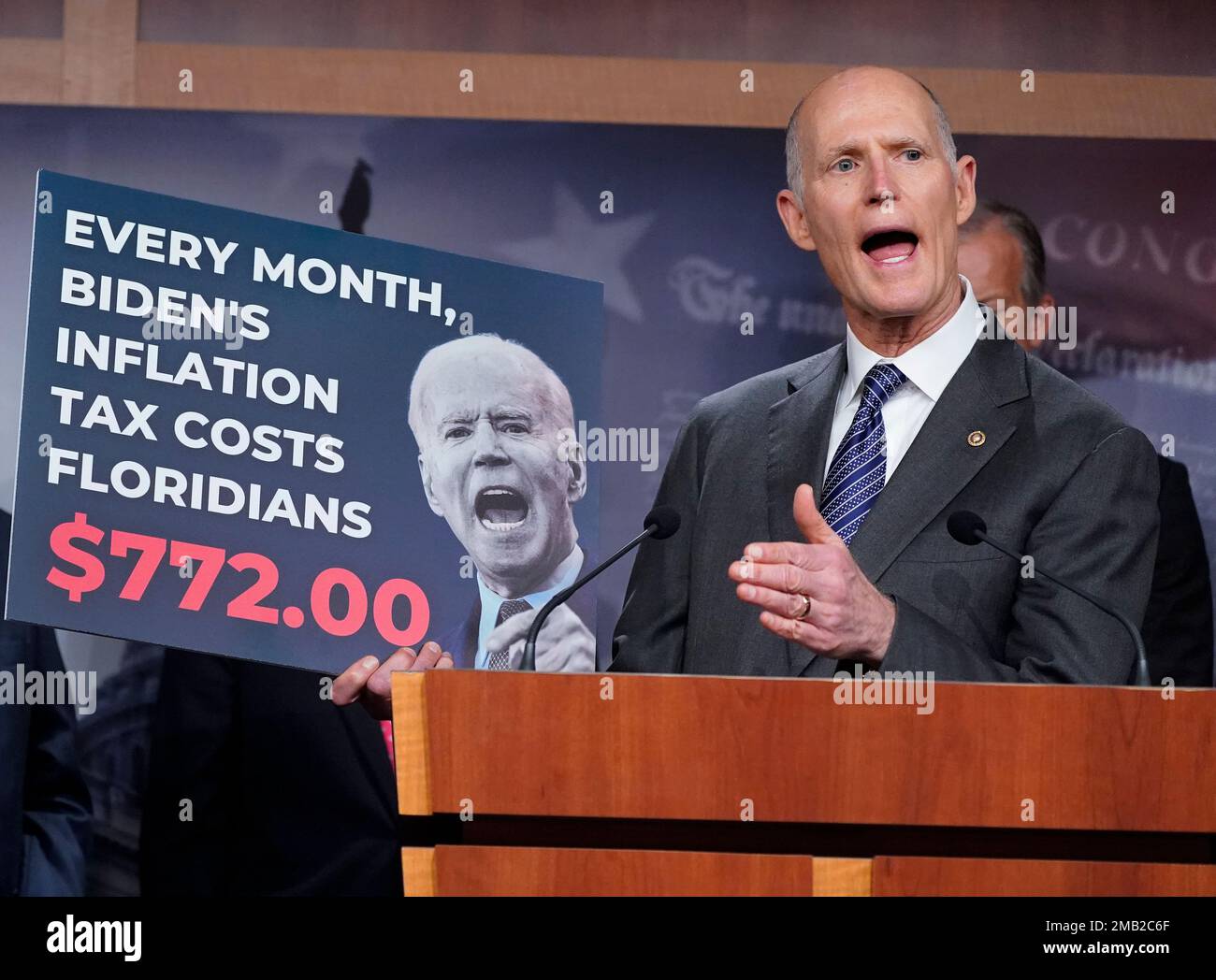 Sen. Rick Scott, R-Fla., holds up a poster as he speaks with reporters ...