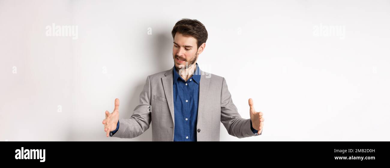 Excited handsome businessman showing long size thing, big object with ...