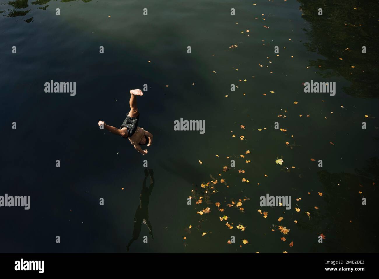 Kids jump from a bridge to swim in the Canal St. Martin, during a heat ...
