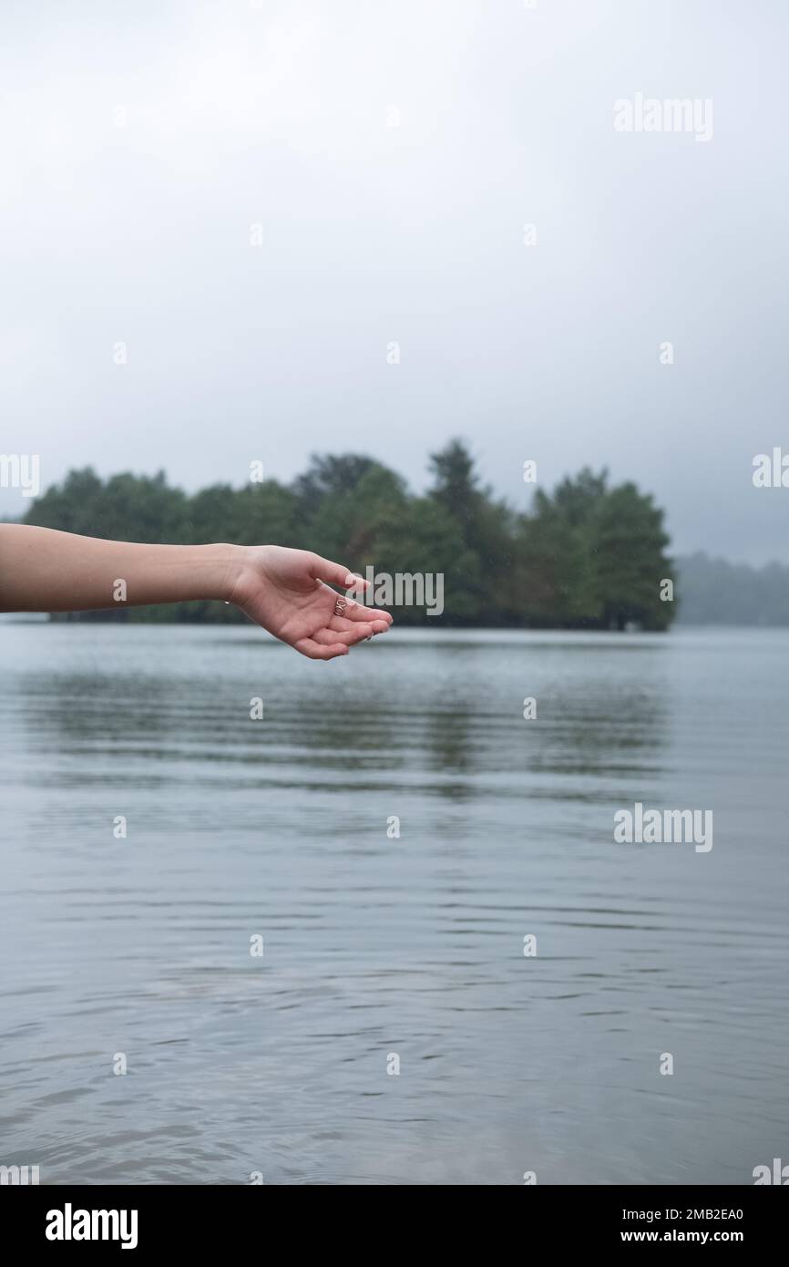 A beautiful tranquil scenery of a lake with a gentle hand of a female ...
