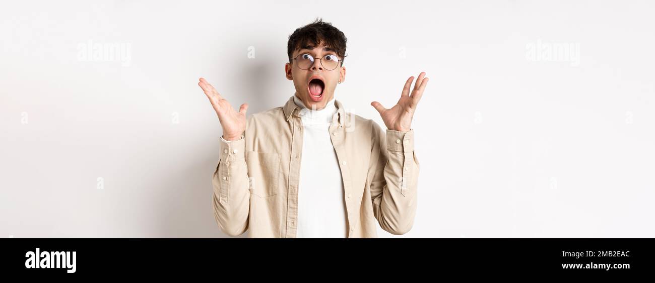 Scared young man in panic, screaming and looking axious, jumping ...