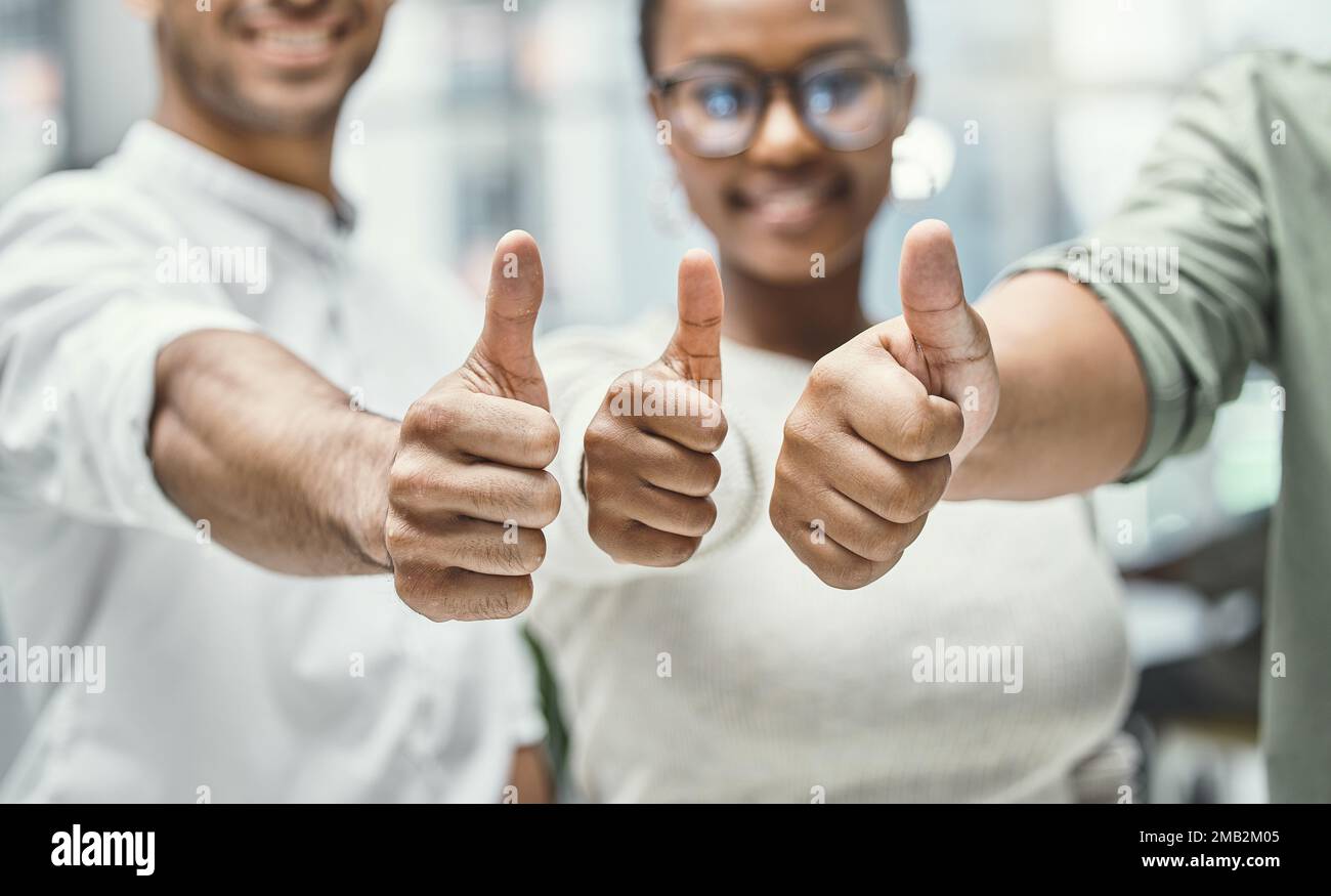 Move forward through teamwork. three businesspeople showing thumbs up ...
