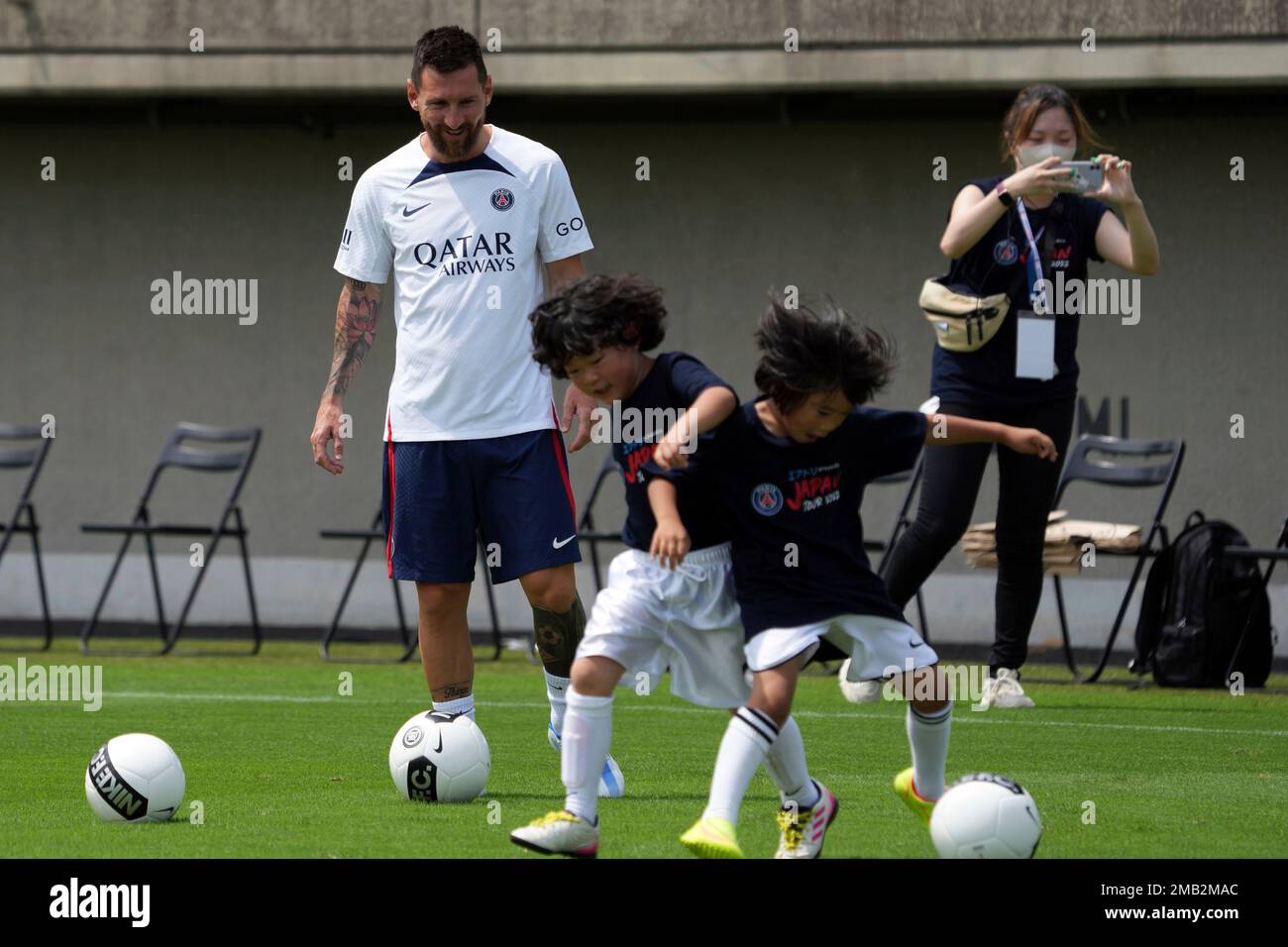 Paris Saint-Germain soccer player Lionel Messi looks at children ...