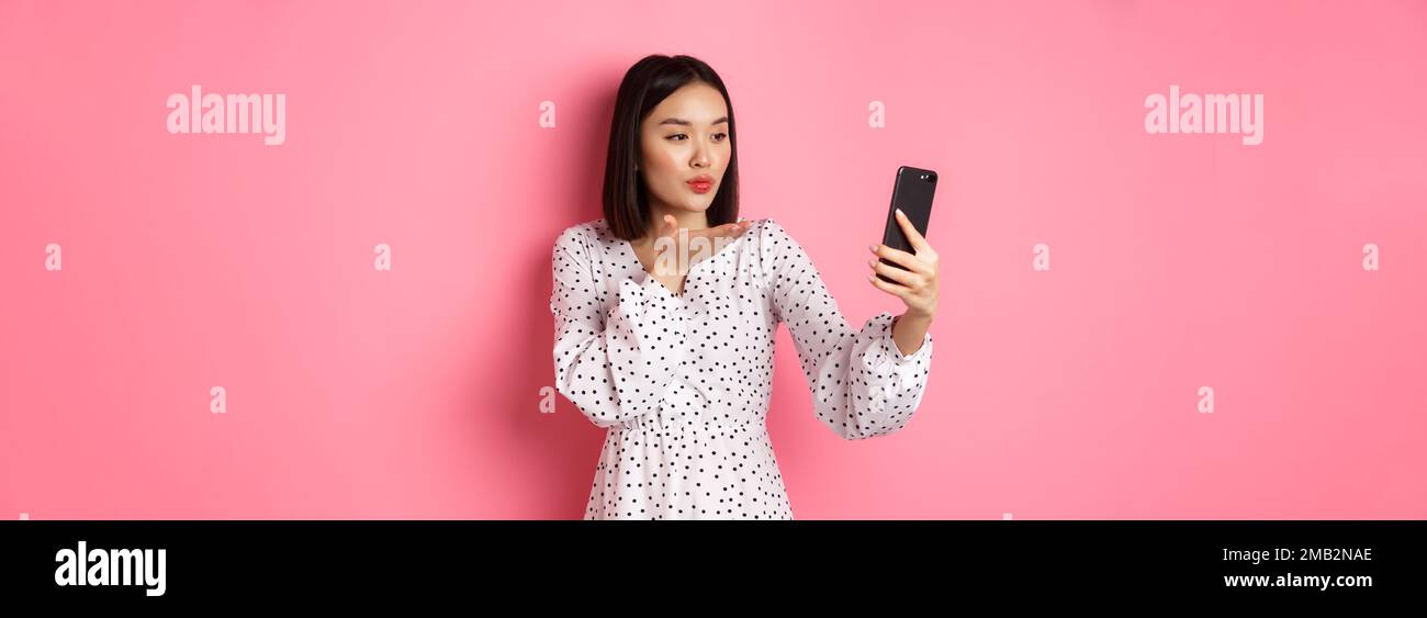 Beautiful asian girl using photo filters app and taking selfie on ...