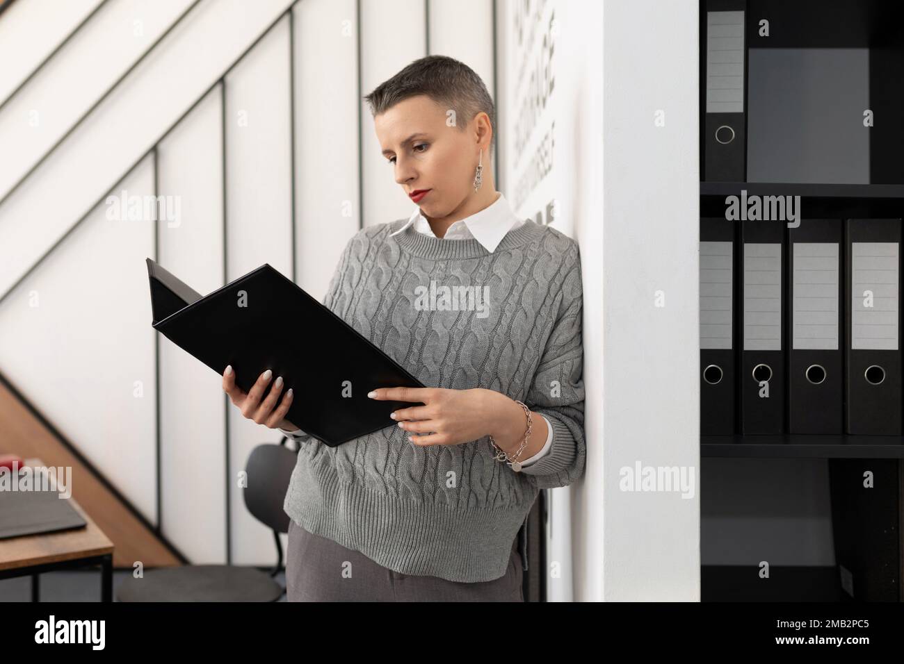 Business woman accountant with a short haircut stands in the office ...
