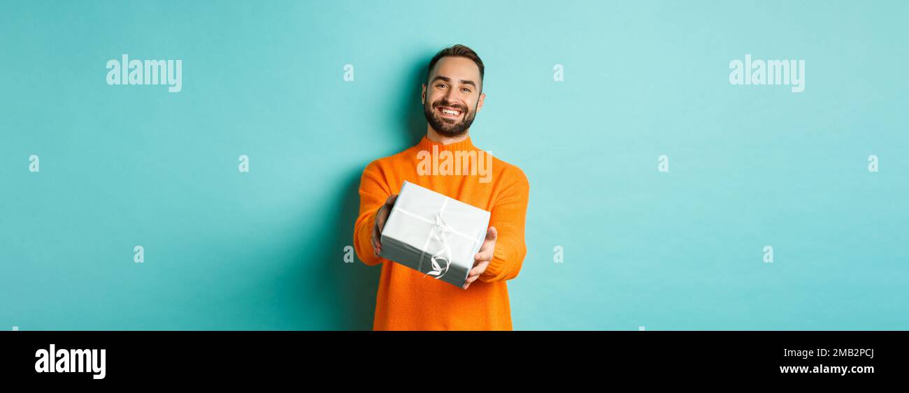 Holidays and celebration concept. Happy man giving you a gift ...