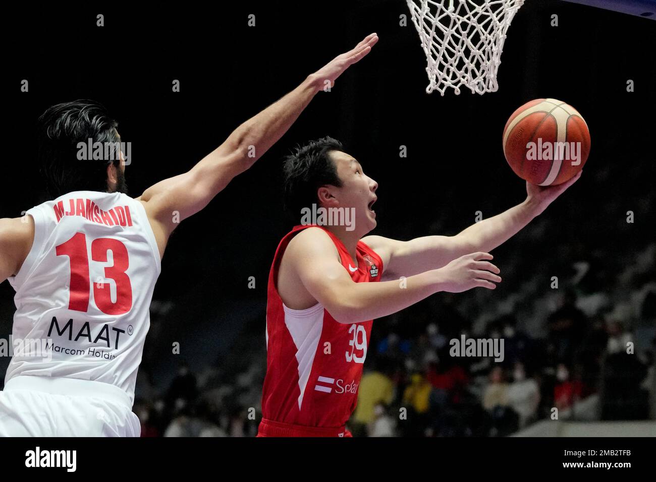 Japan's Keisei Tominaga, right, shoots against Iran's Mohammad Jamshidi during their group phase ...