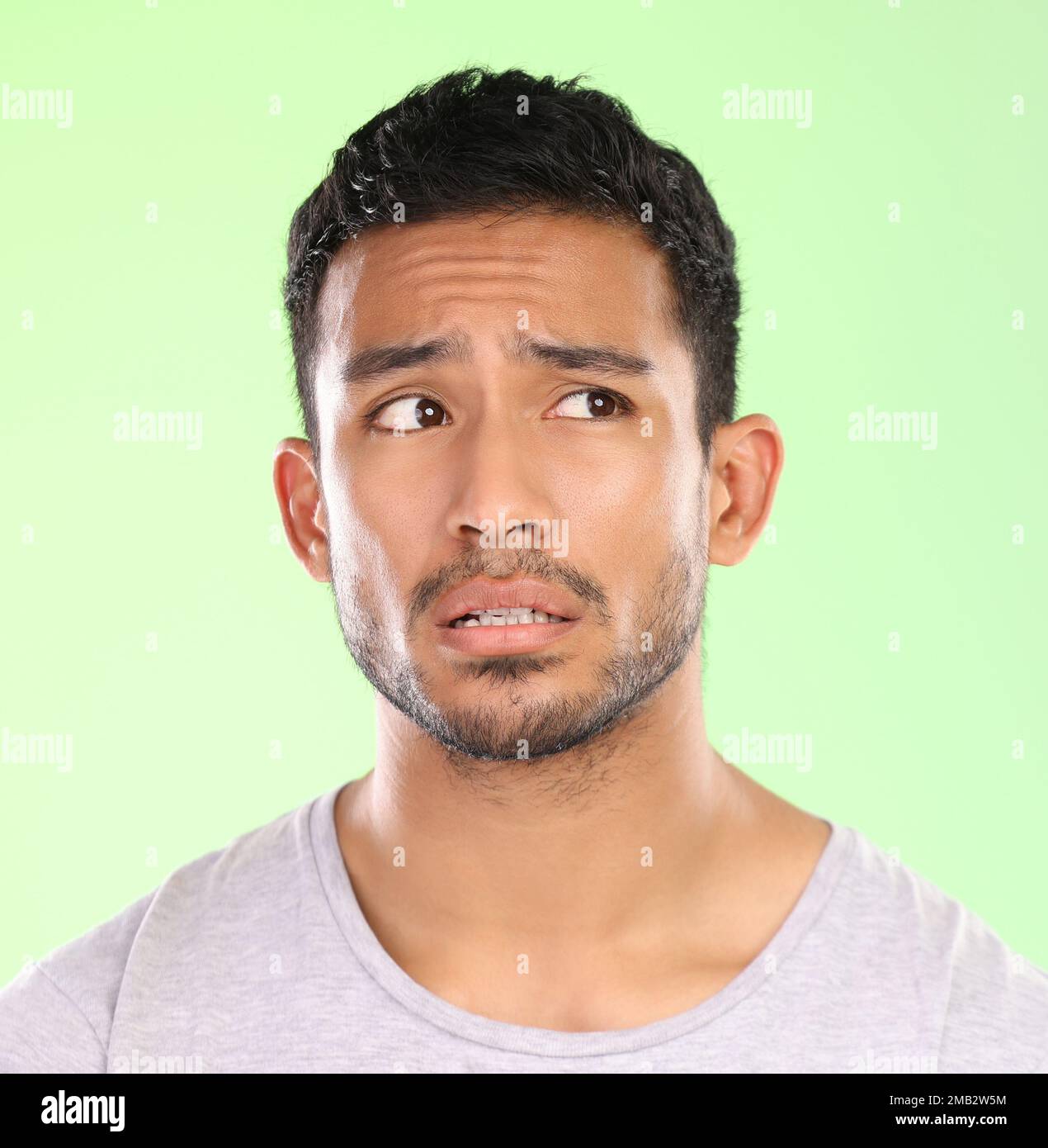 Uhm...a handsome young man making a face against a green background in ...