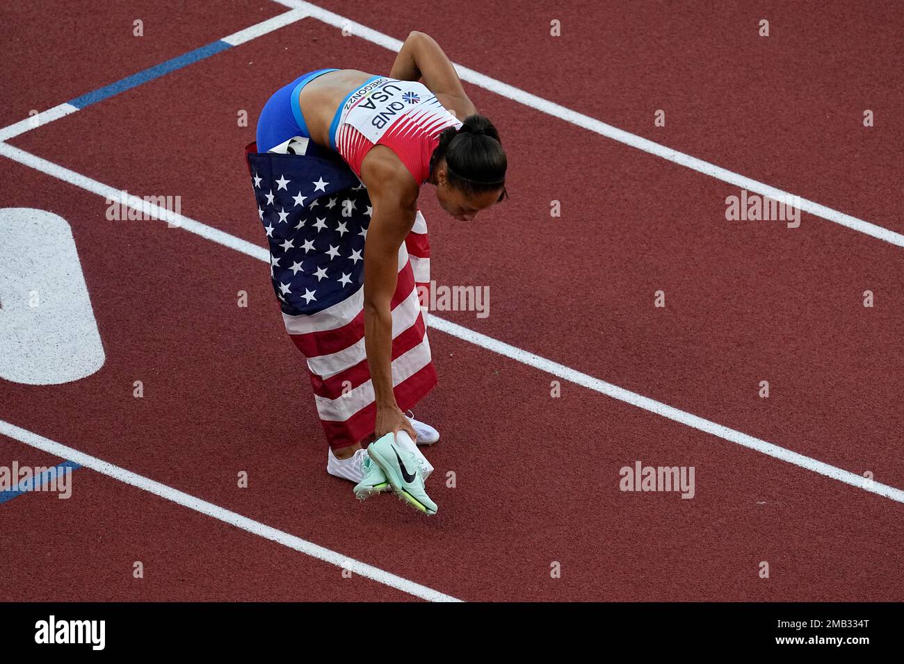 Allyson Felix, of the United States, leaves her shoes on the track ...