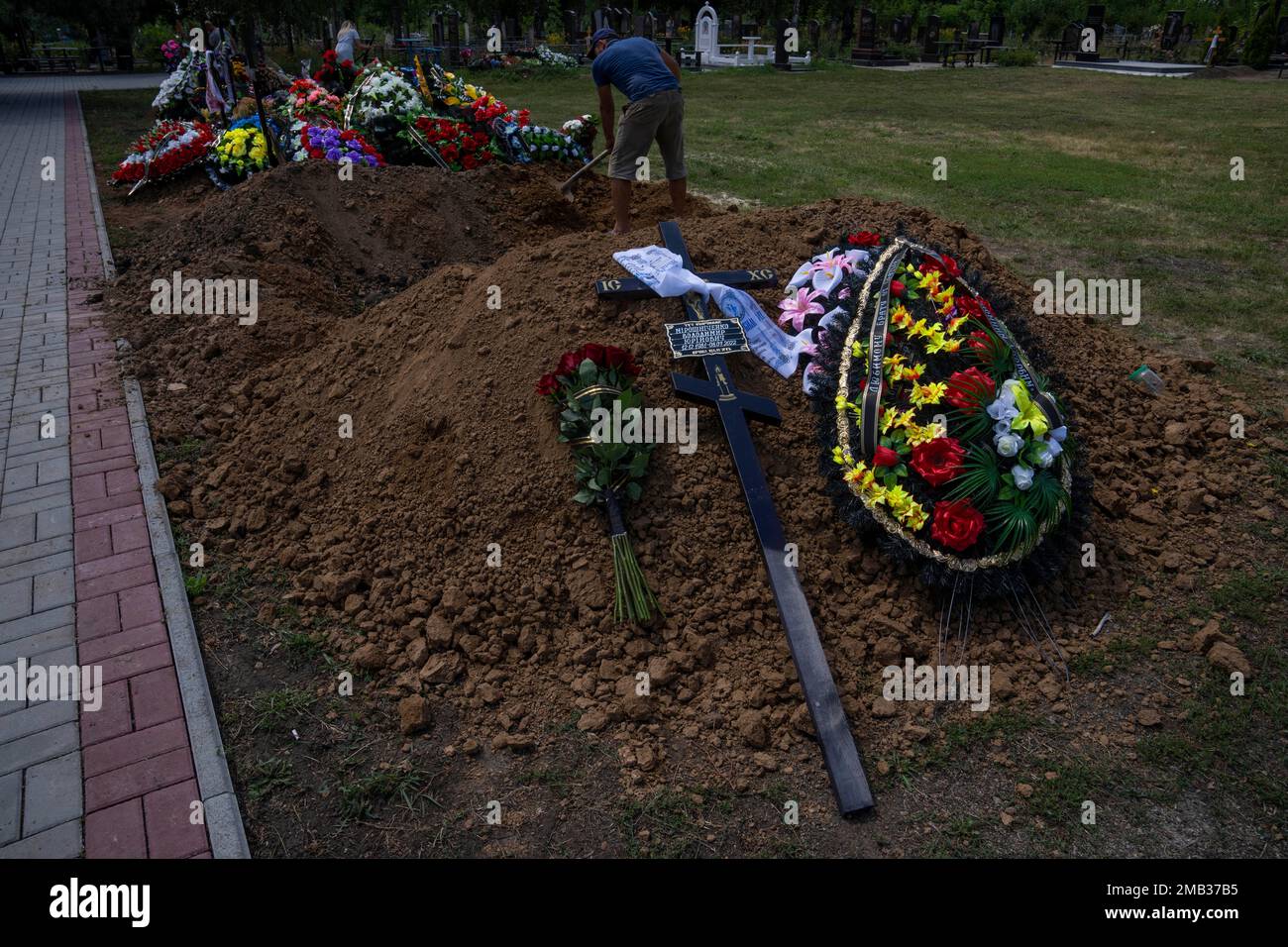 A grave digger uses his shovel to throw dirt on the coffin of 40-year ...