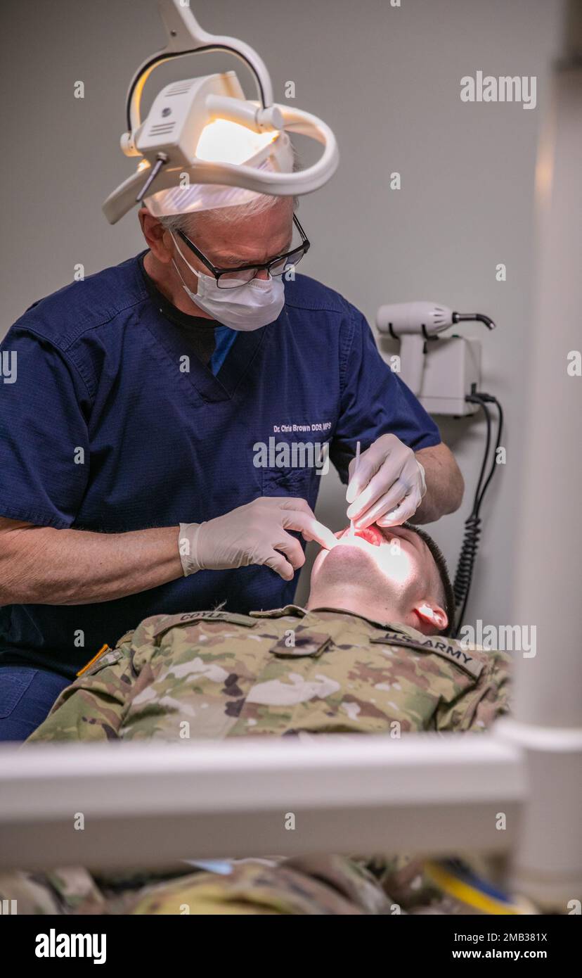 Dr. Christopher Brown examines a soldier's teeth during his dentist ...