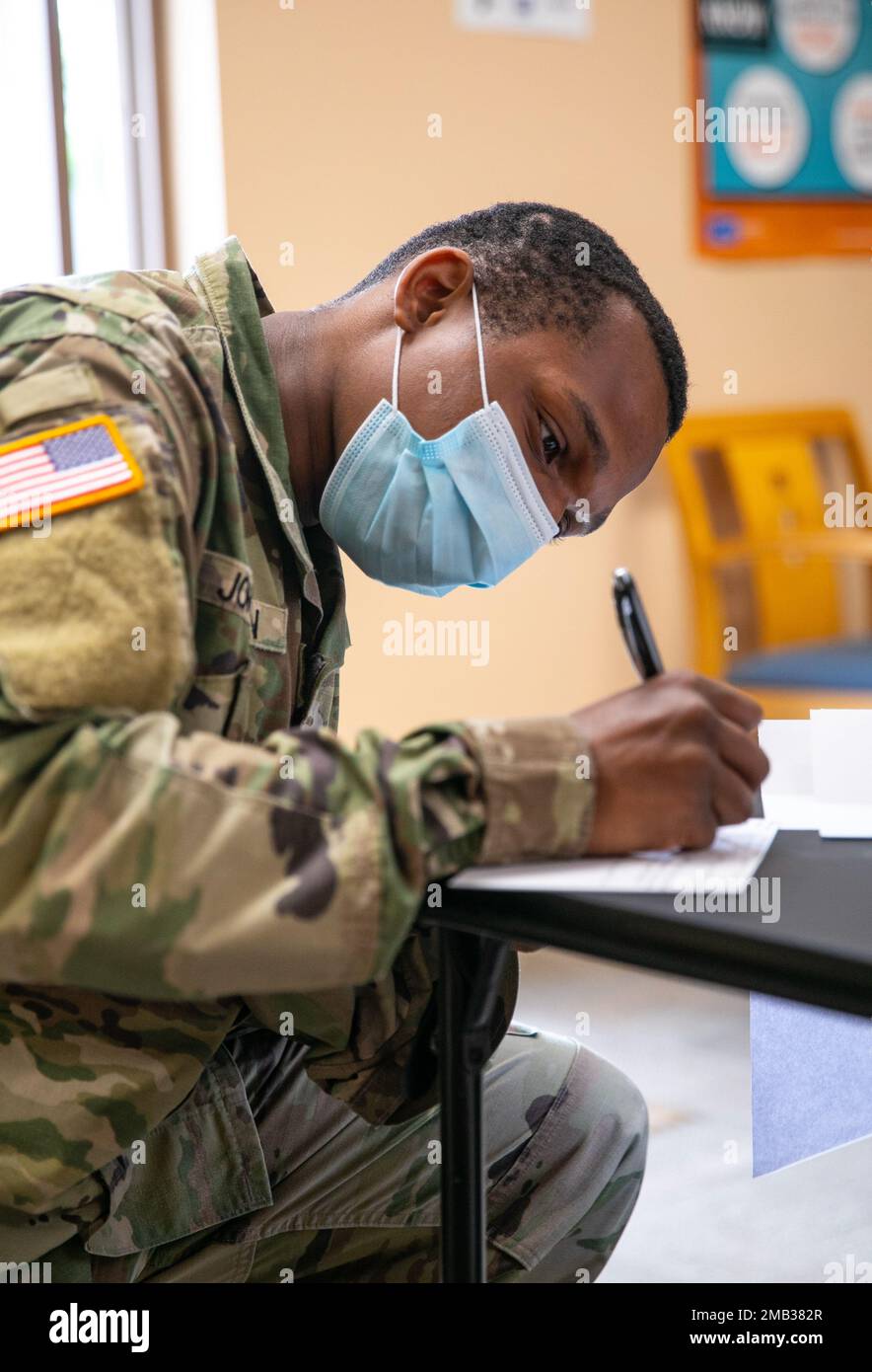 Spc. Johnson from the 310th Sustainment Command (Expeditionary) signs a ...