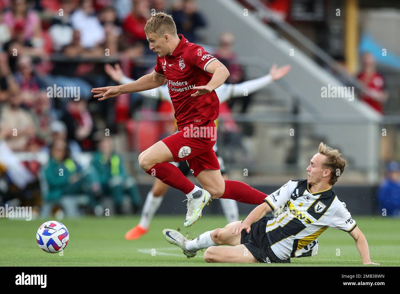 Ben Halloran of Adelaide United is tackled by Jake Hollman of the Bulls ...