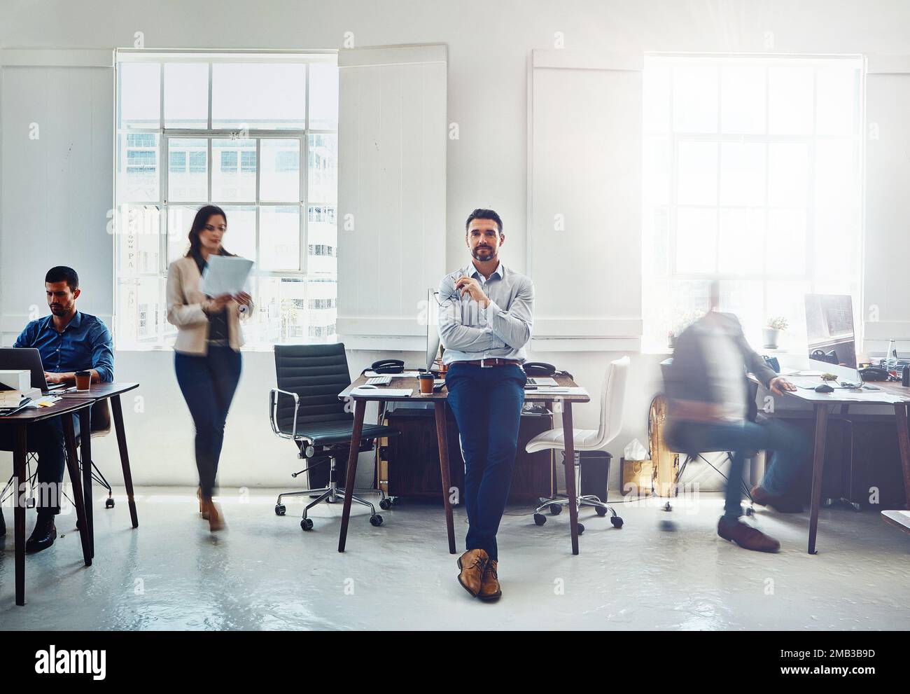 Man, leader and office portrait with business group, sitting and desk ...