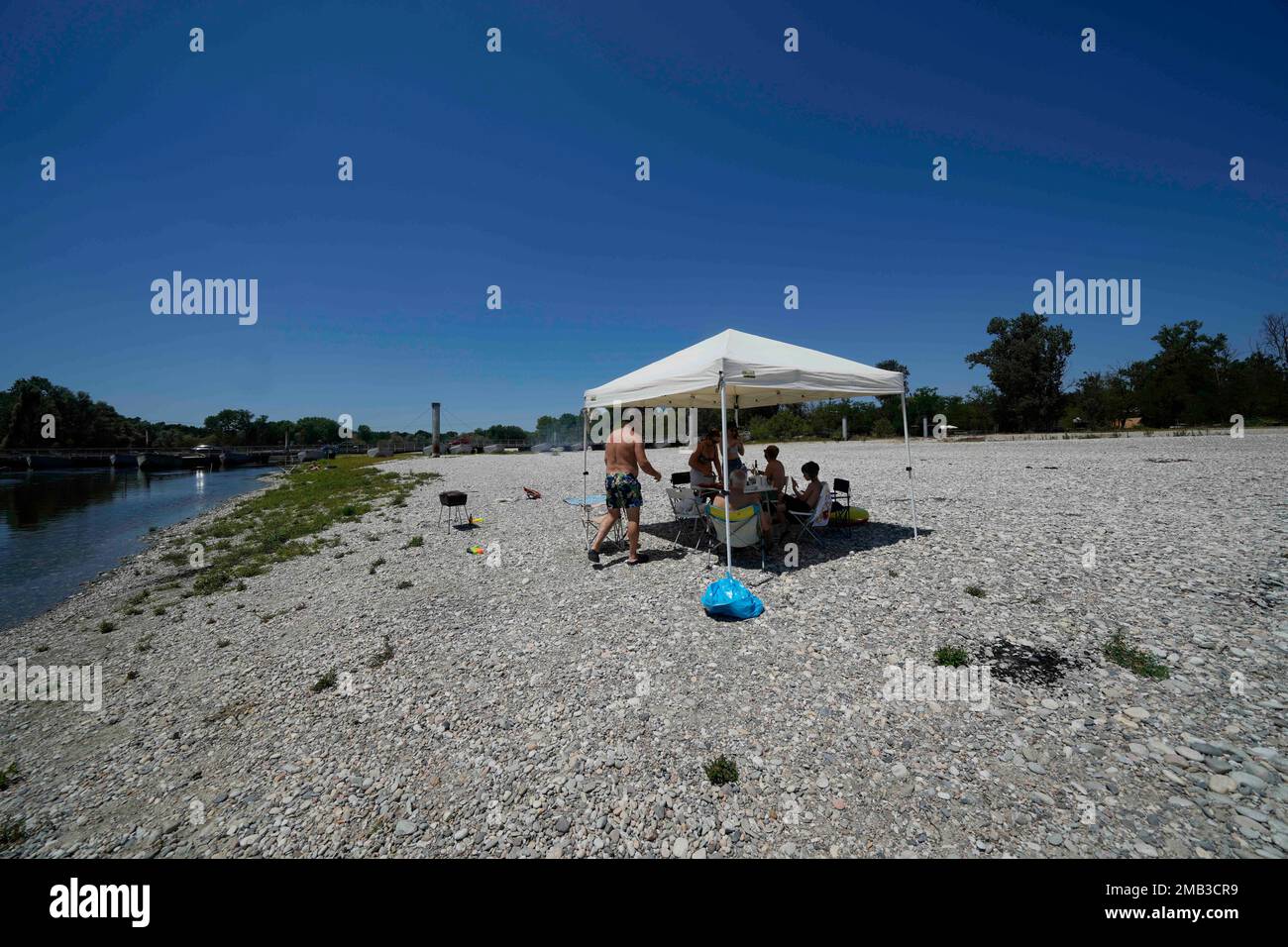 People relax on the Ticino riverbed in Bereguardo, Italy, Friday, July ...