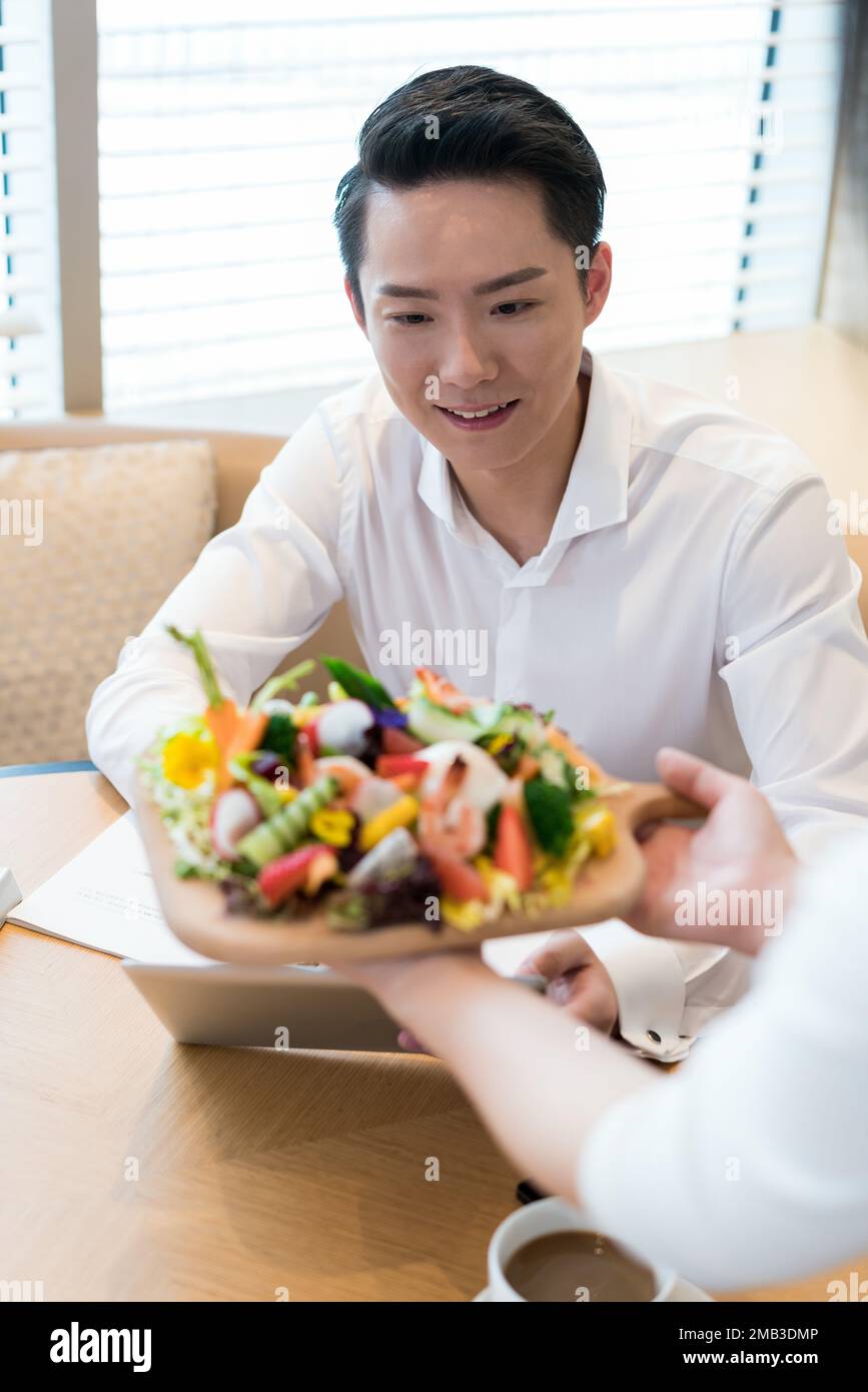 The waiter brought the customer a salad Stock Photo - Alamy