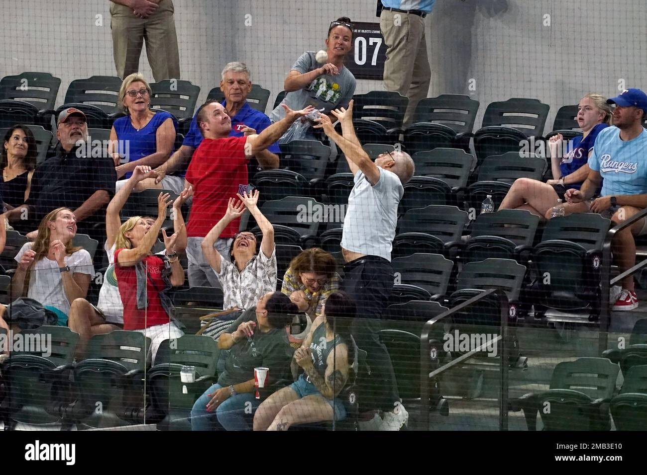 Fans reach up for a ball thrown to them by an Oakland Athletics player ...