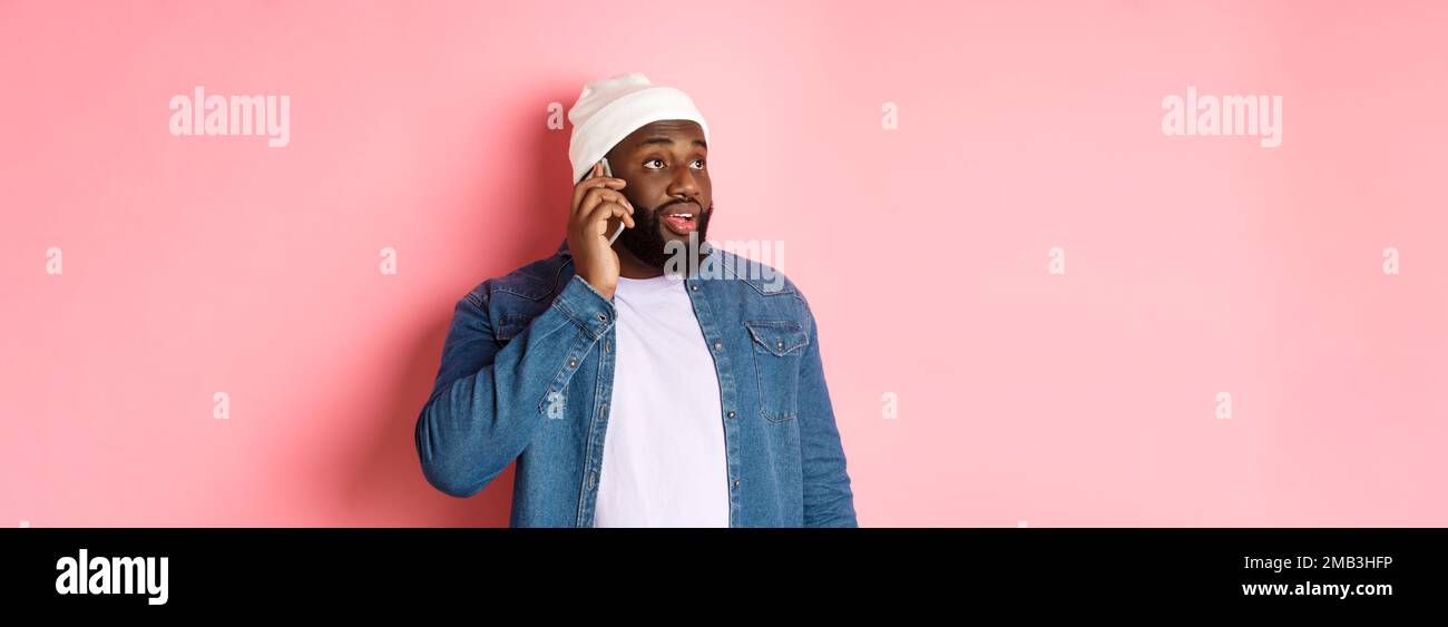 Hipster Black man talking on phone, looking left and having mobile ...