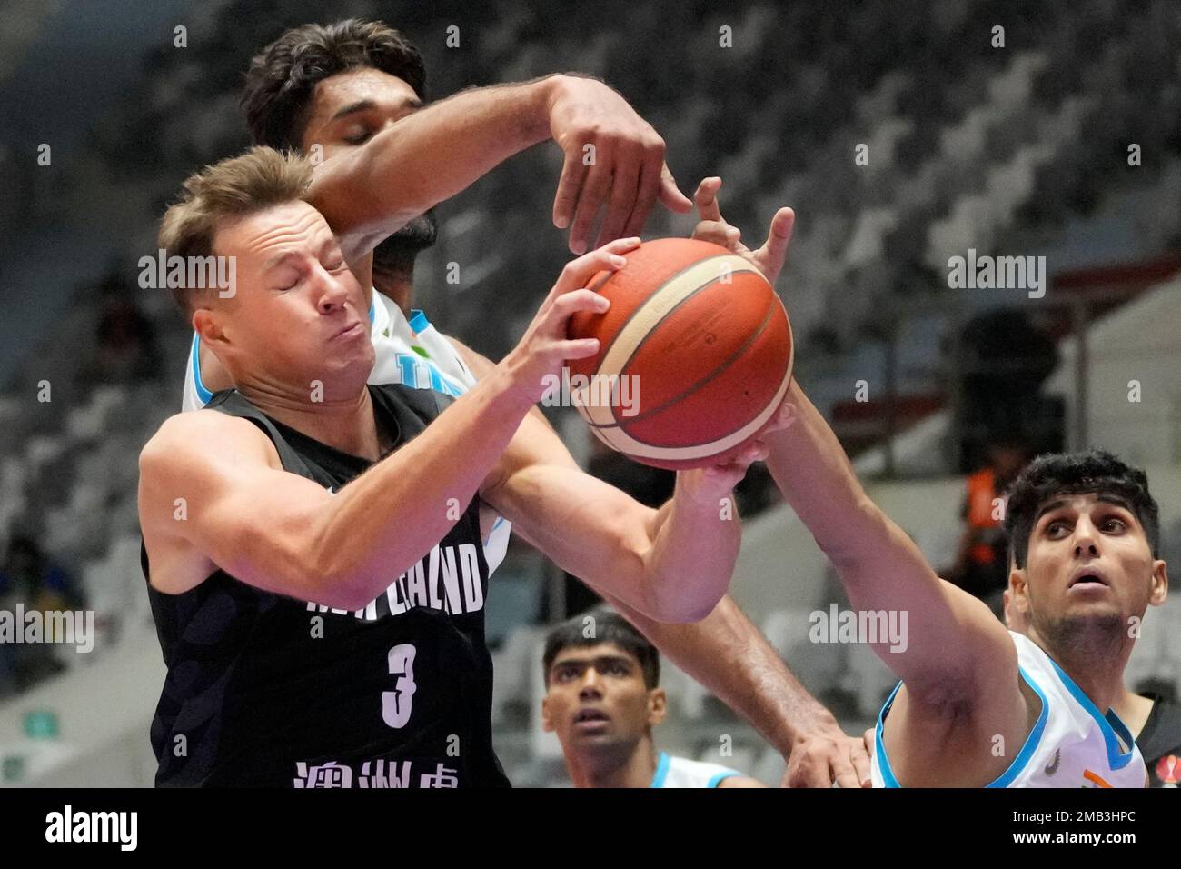 New Zealand's Sam Mennenga, left, battles for a rebound against India's ...