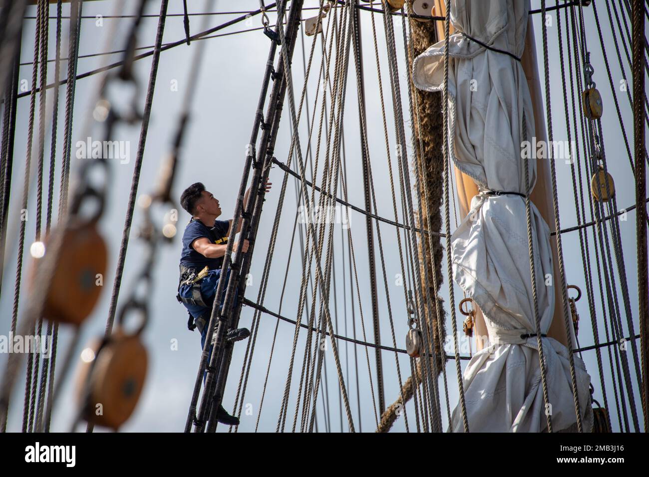 A Coast Guard cadet climbs the rigging aboard Coast Guard Cutter Eagle ...