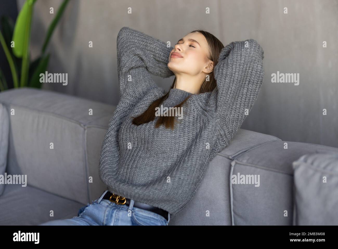 Finally weekends. Millennial girl relaxing at home on couch, enjoying ...