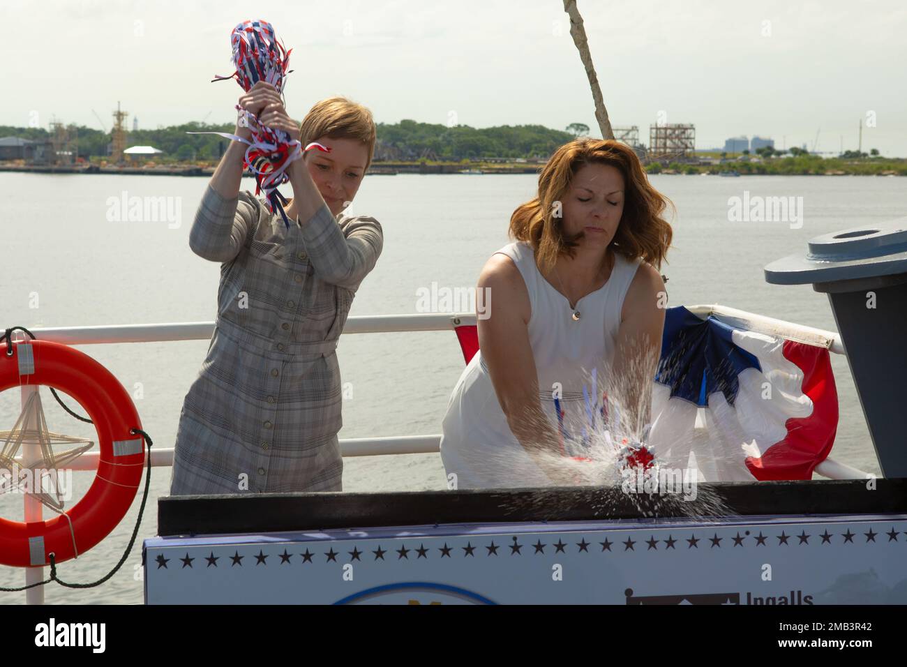 Kate Oja, left, and Shana McCool break champagne bottles as part of a ...